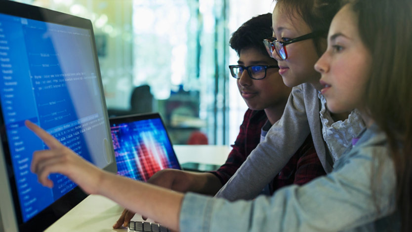 Students programming at computer in computer lab classroom